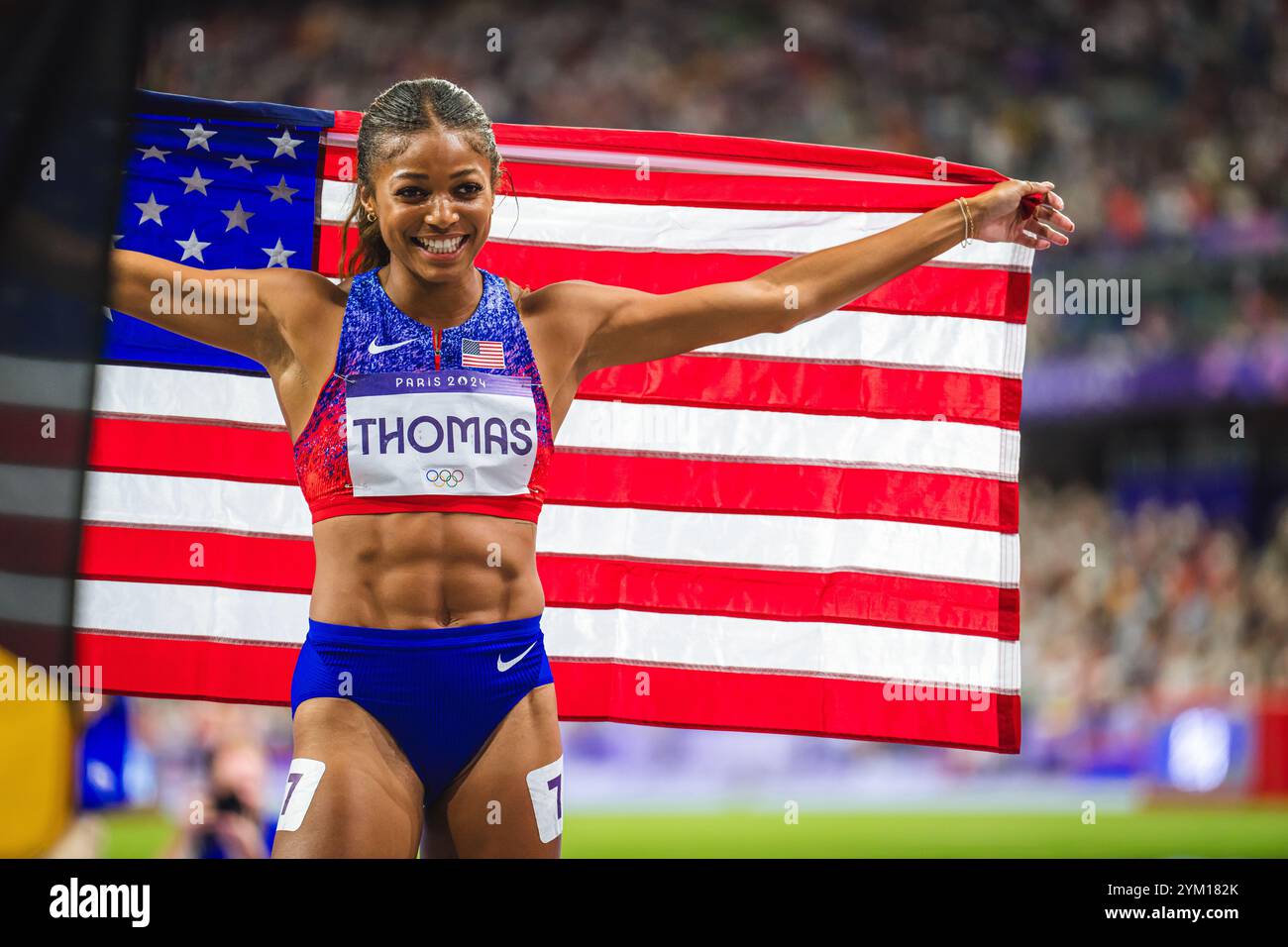 Gabrielle Thomas celebrating with her country's flag in the 200 meters ...