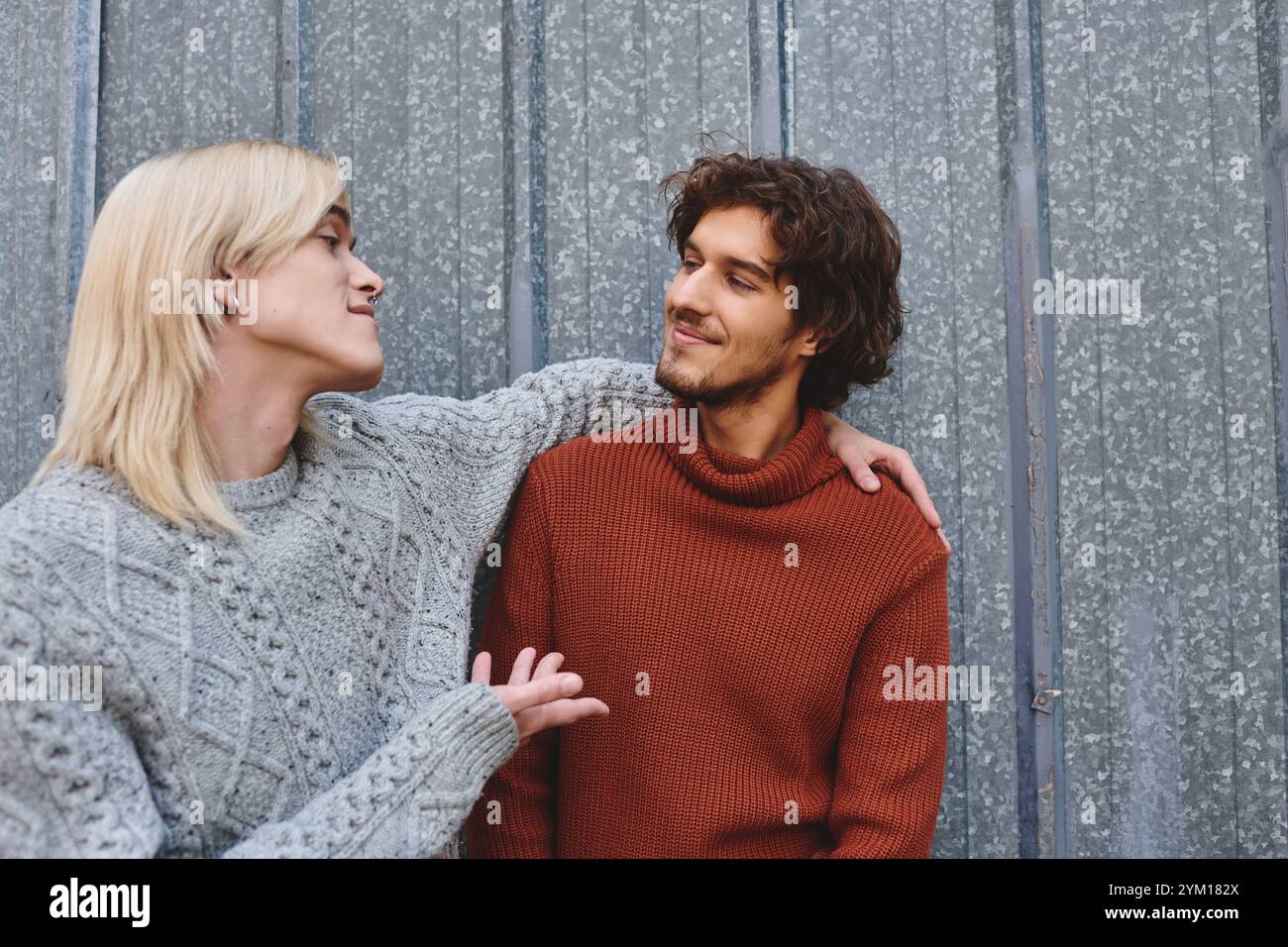 Two young men engage warmly in conversation, their expressions ...