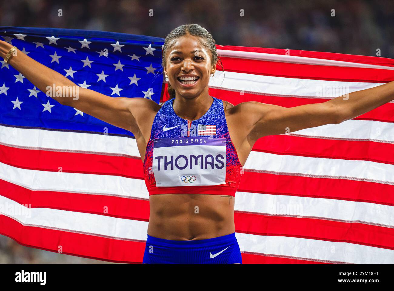 Gabrielle Thomas celebrating with her country's flag in the 200 meters ...