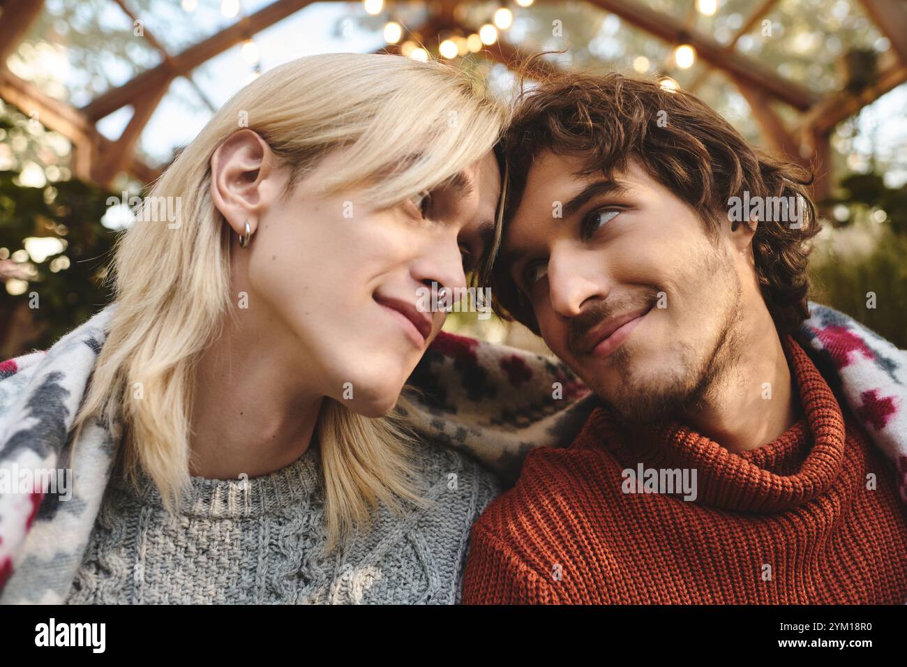 Two handsome young men share a tender moment together, wrapped in a ...