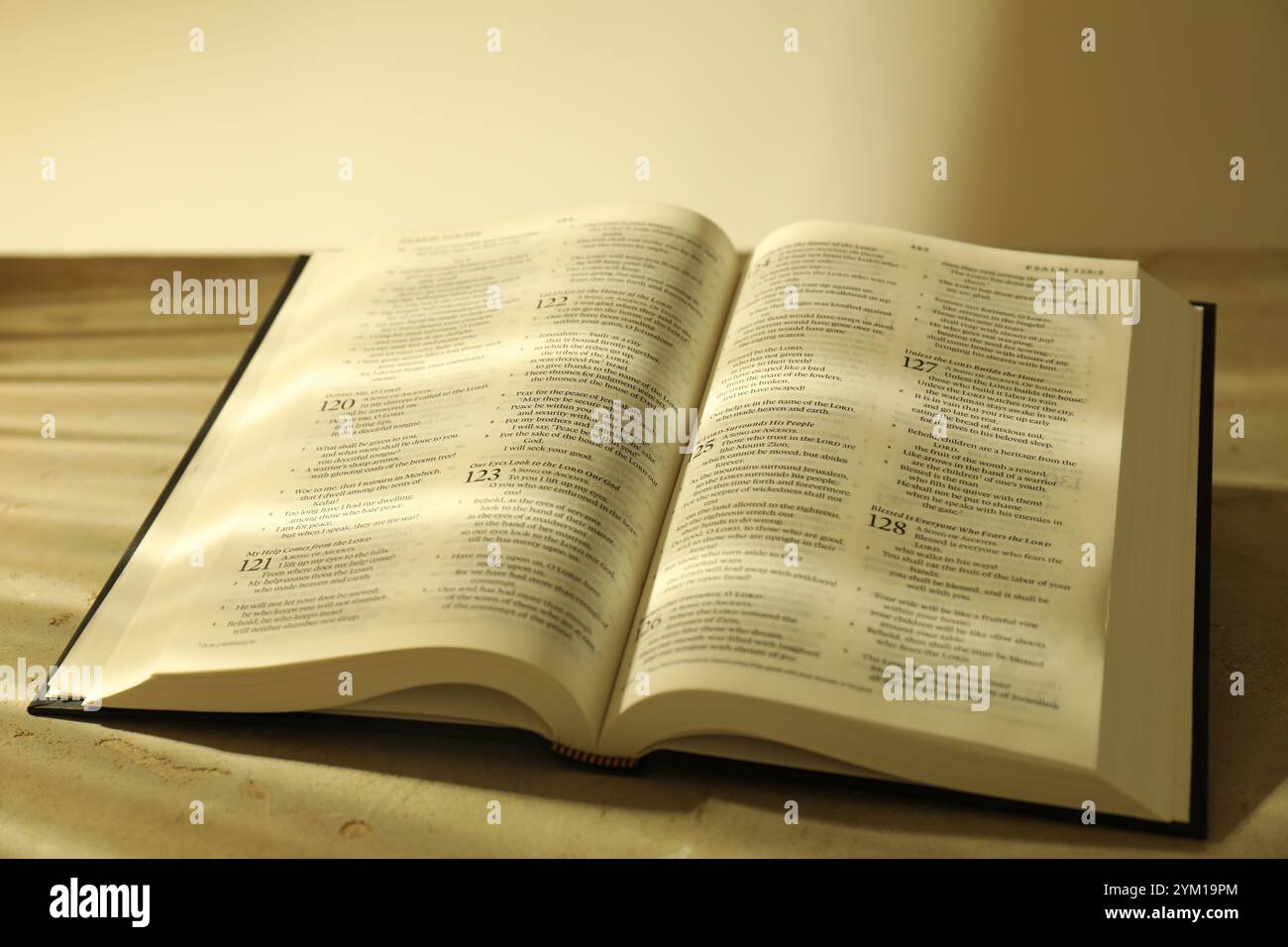 Open Holy Bible in English language on beige table, closeup Stock Photo ...