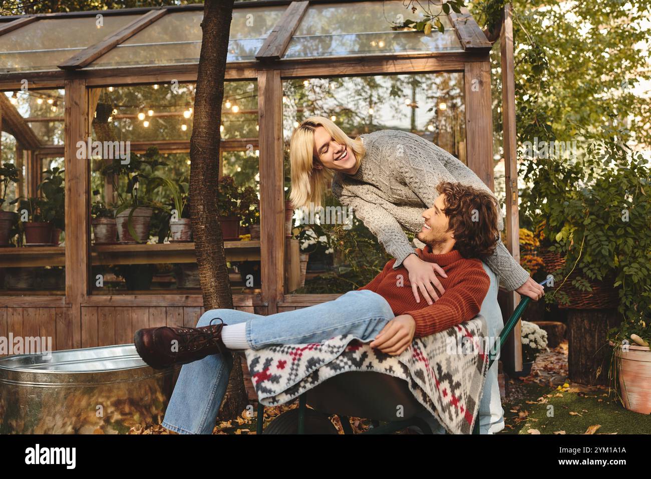 In a vibrant garden, a joyful young couple shares laughter as one ...