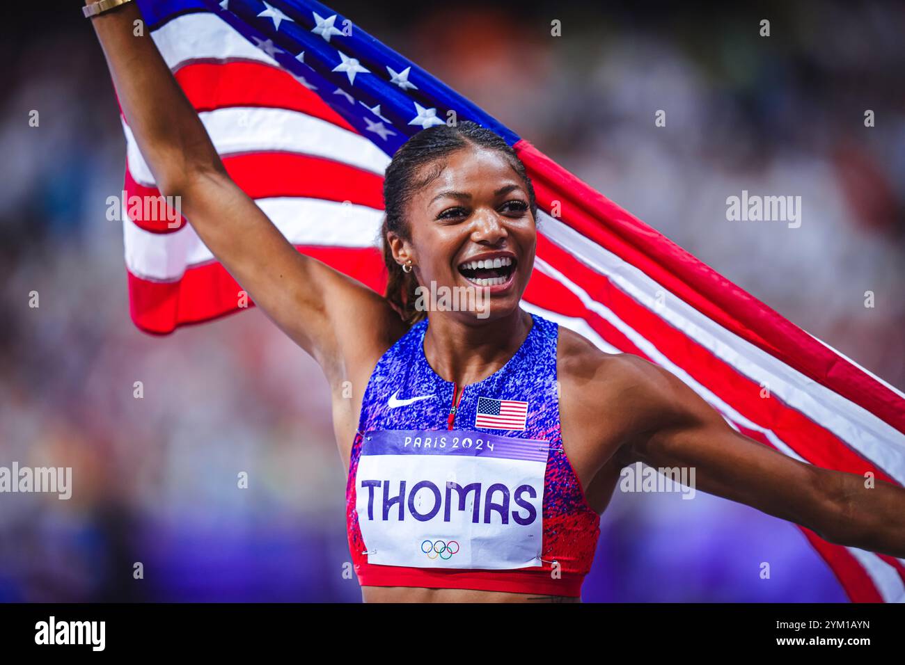 Gabrielle Thomas celebrating with her country's flag in the 200 meters ...