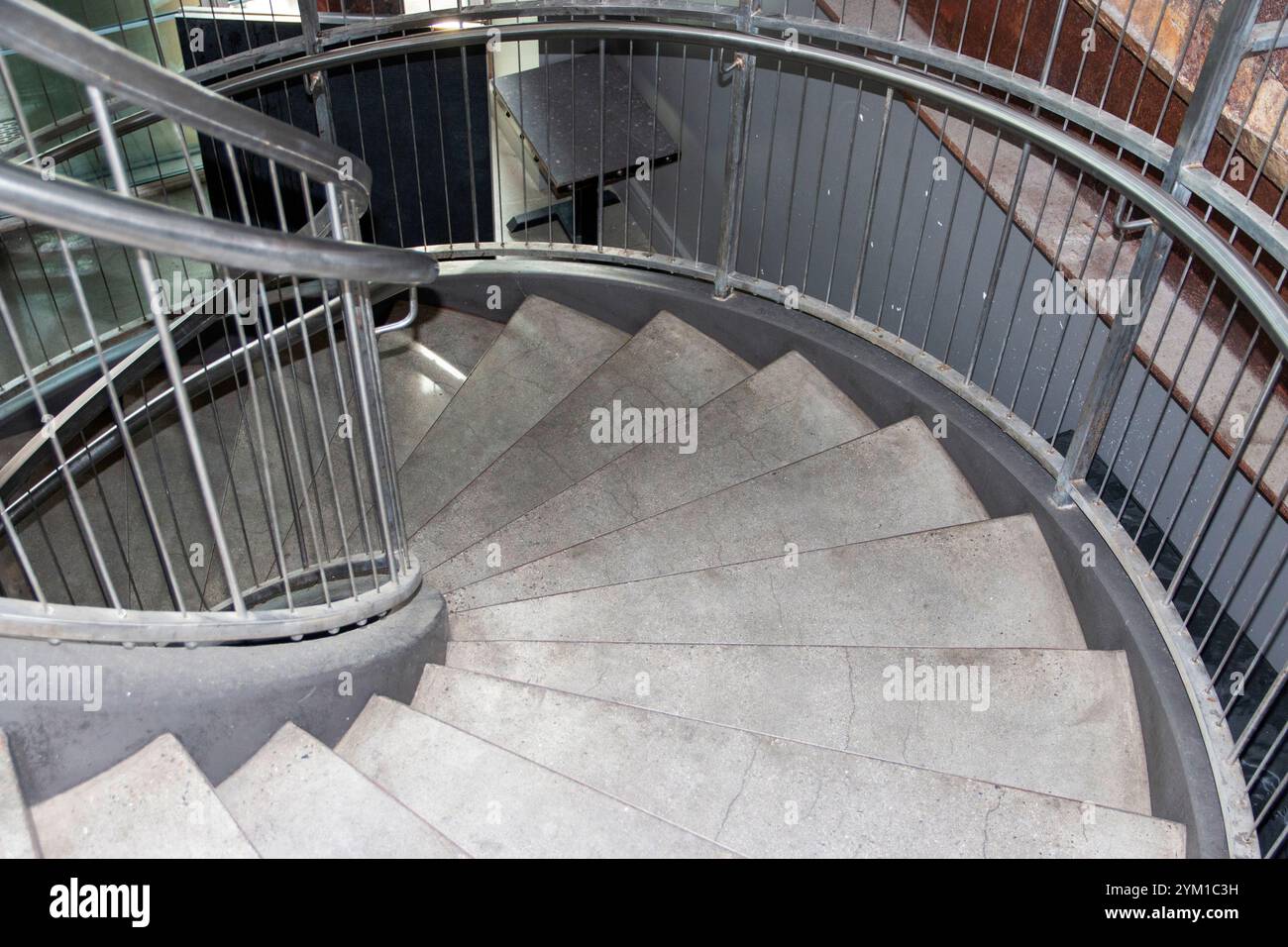 A well-designed spiral staircase with smooth concrete steps and metal ...