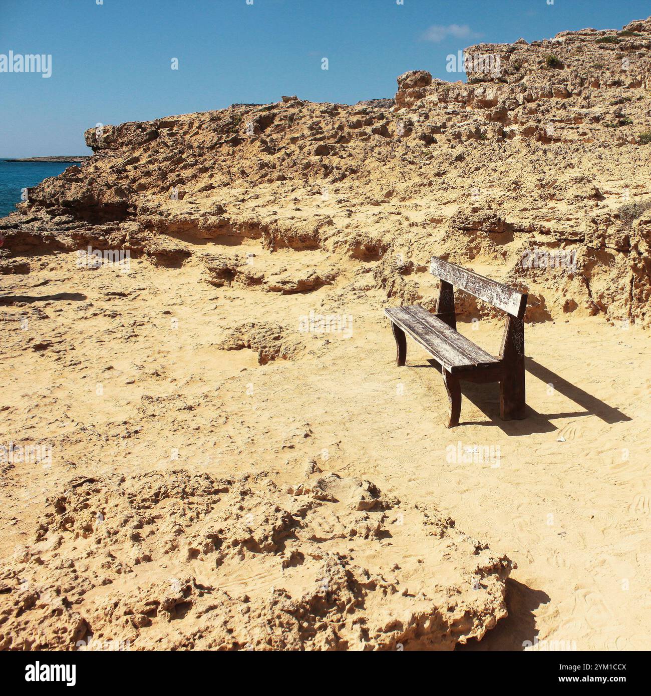 A lonely wooden bench on the seaside. Old bench in Cape Capo Greco ...