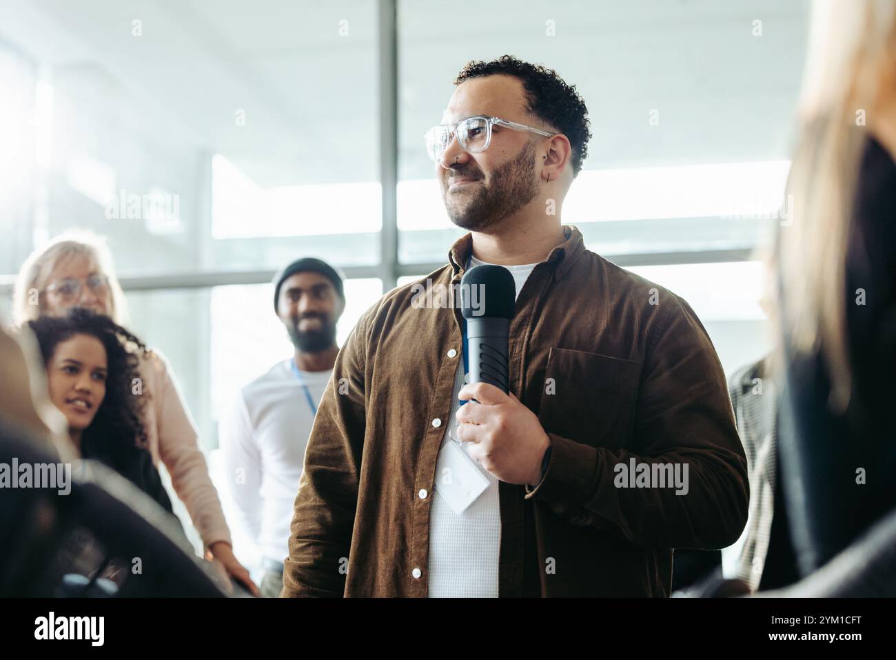 Confident entrepreneur presents to a diverse and engaged audience in a ...