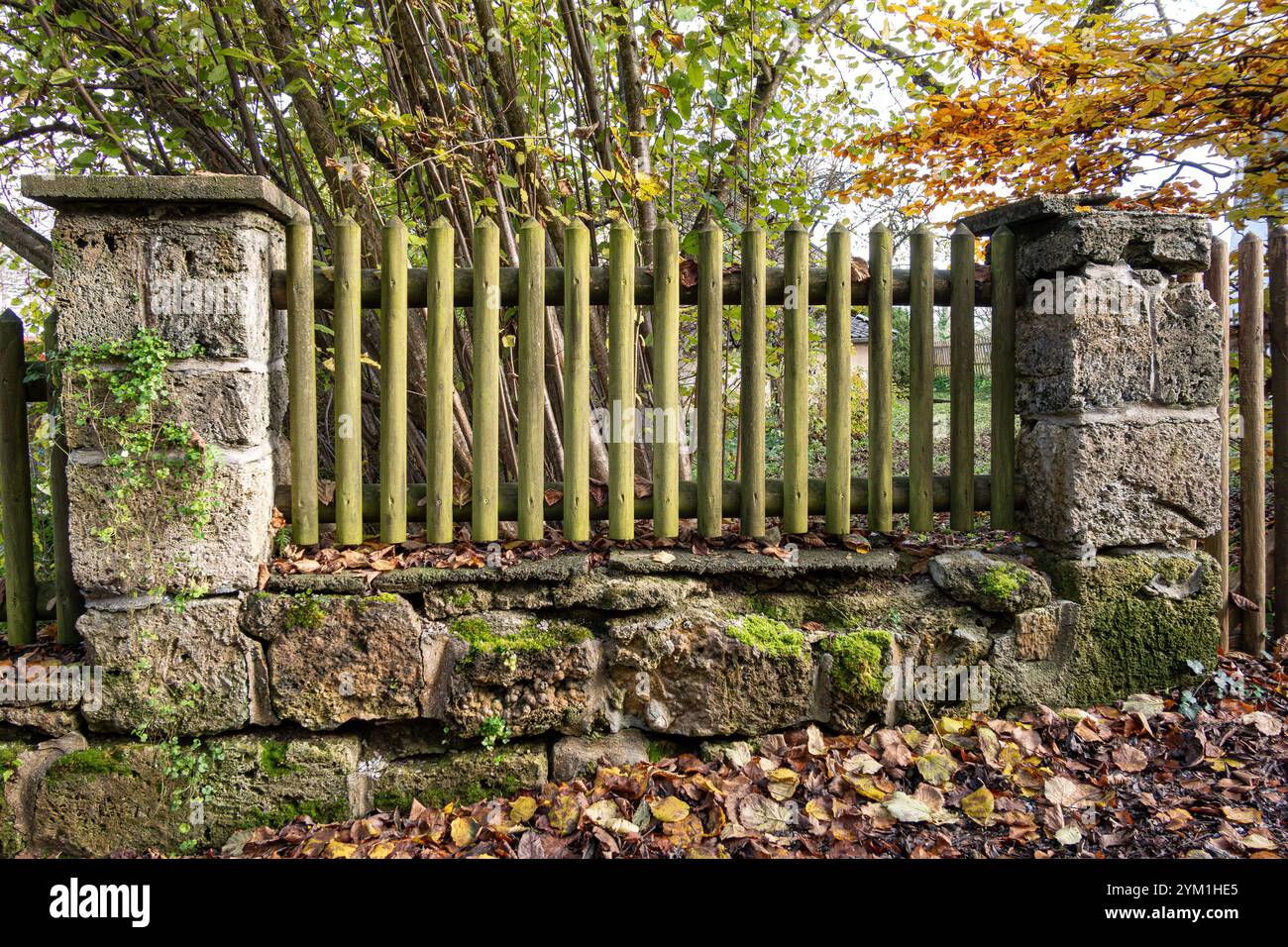 Wooden fence with old mossy stone wall and pillars Stock Photo - Alamy