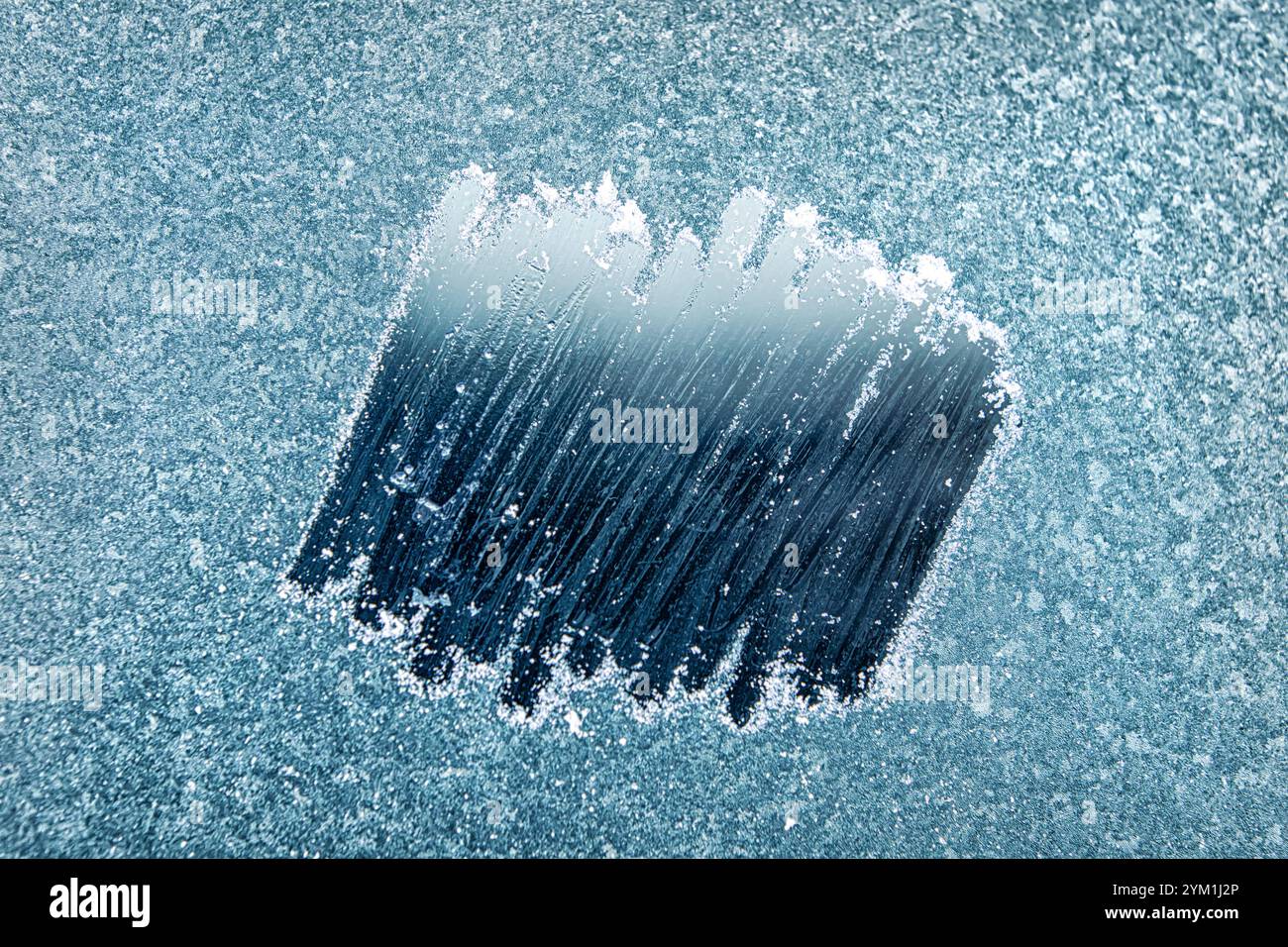 A frosted window displays intricate ice patterns, while a clear patch ...