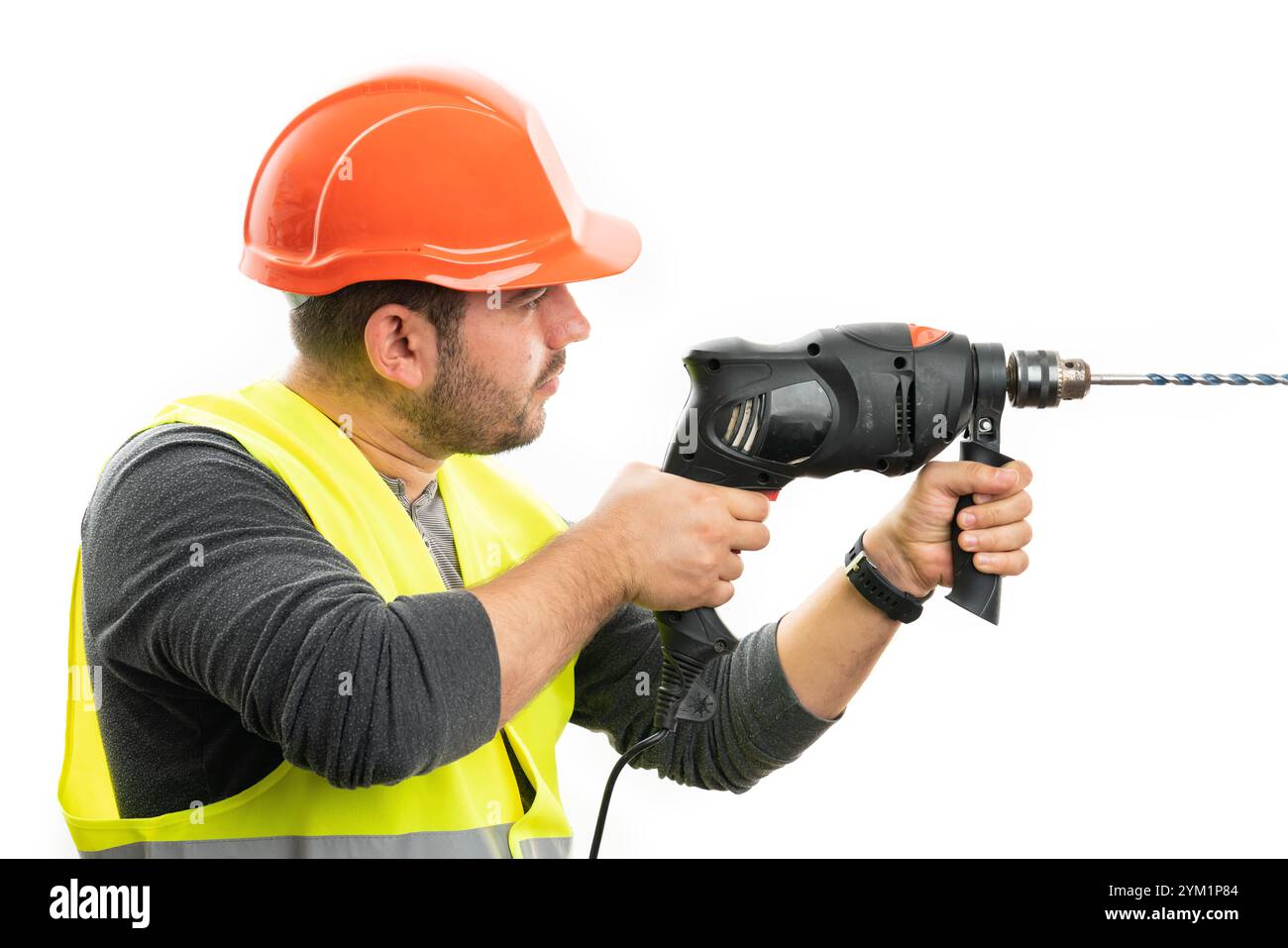 Focused expression male builder frilling hole using electric tool into ...