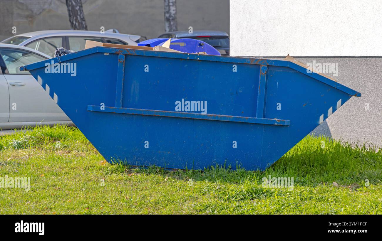 Blue Skip Waste Open Top Metal Container at Green Grass Stock Photo - Alamy