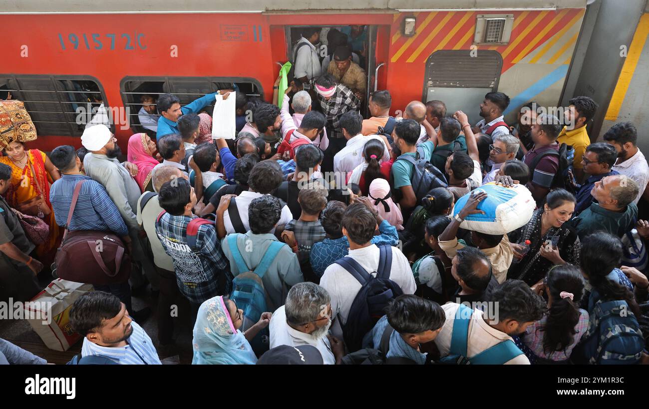 A crowd of passengers scramble to board a train at the railway station ...