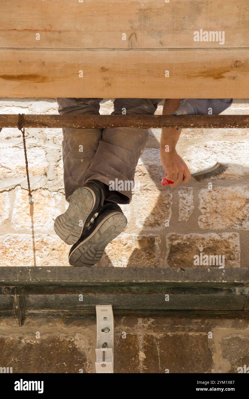 Builder / worker repointing / pointing / mortar, historic stone wall ...