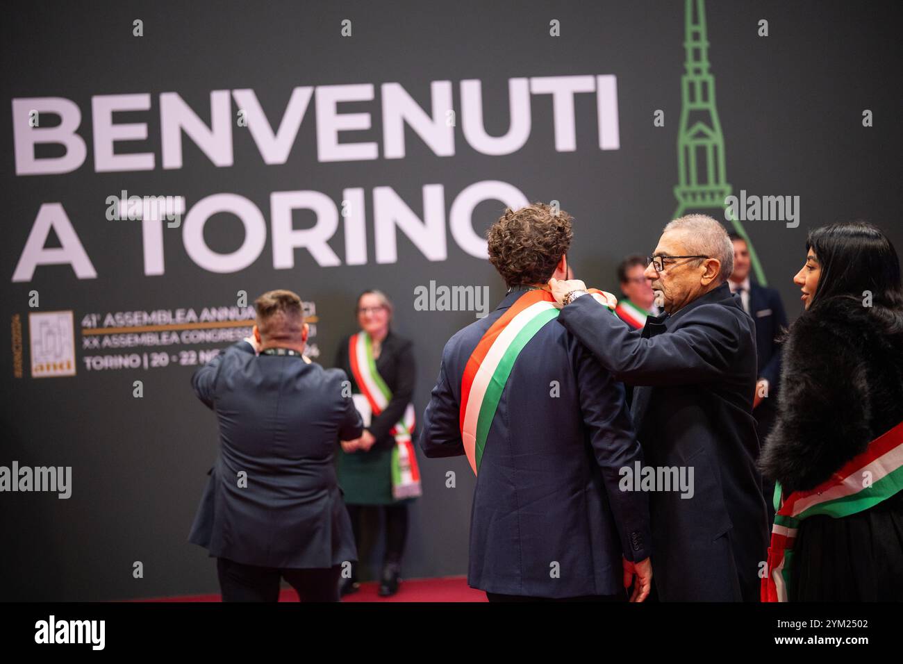 Mayors pose in front of the logo of the ANCI Annual General Meeting at ...