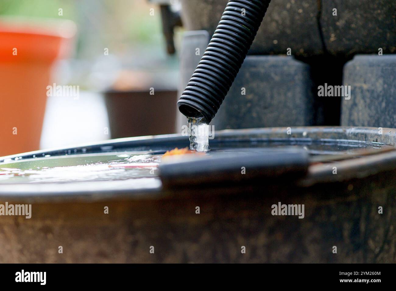 Ice forms at the end of a pipe blocking the flow of water into an overflow bucket Stock Photo ...
