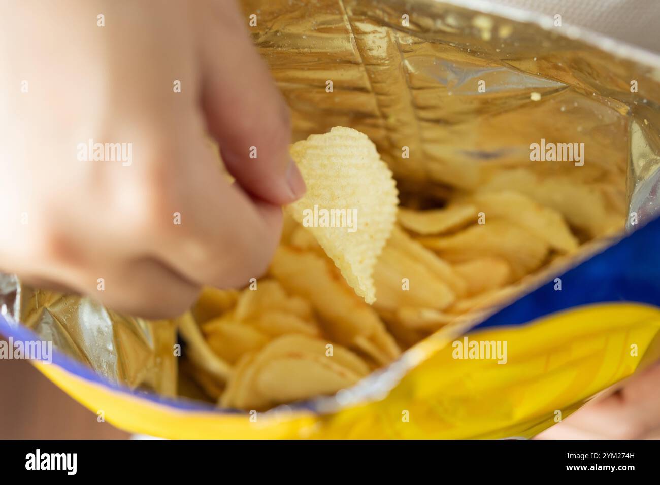 Hand hold potato chips with snack bag Stock Photo - Alamy