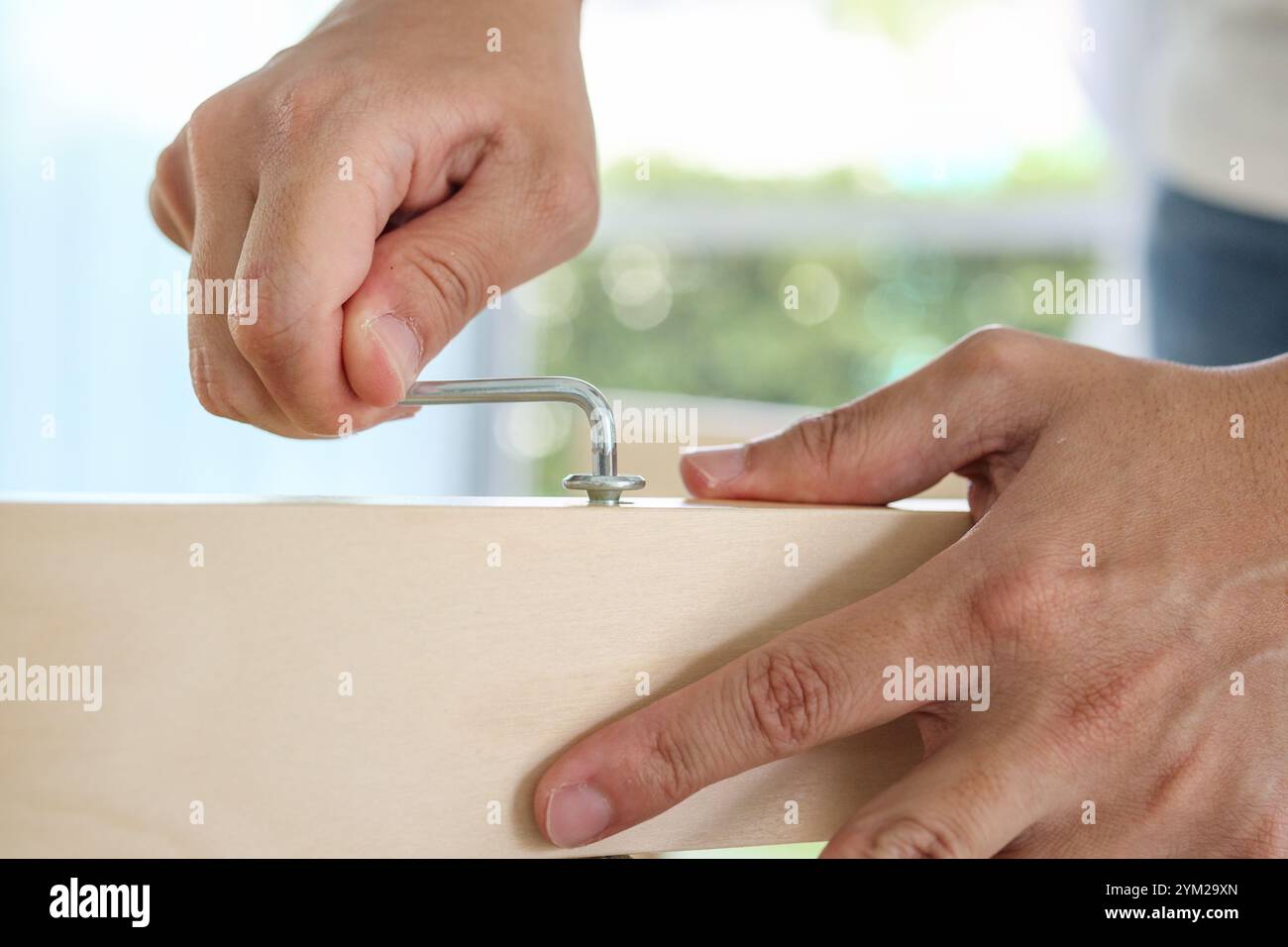 Assembly wooden furniture at home using screw allen Stock Photo - Alamy