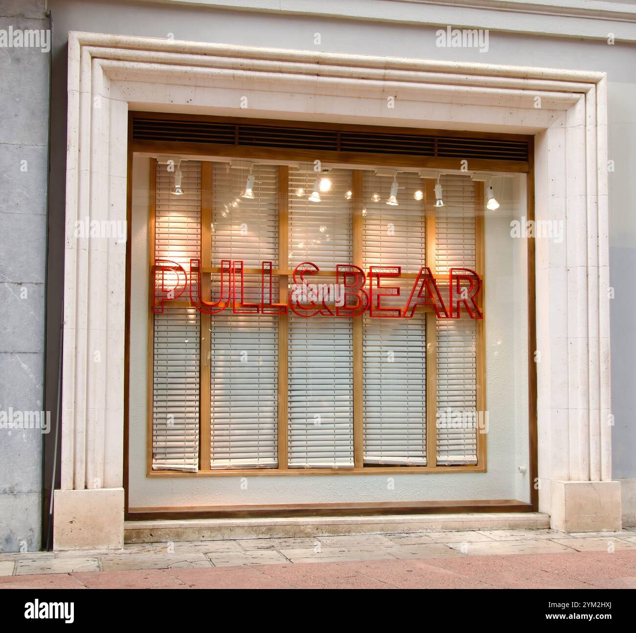 Framed arch shop window with Venetian blinds and sign for Inditex Group ...