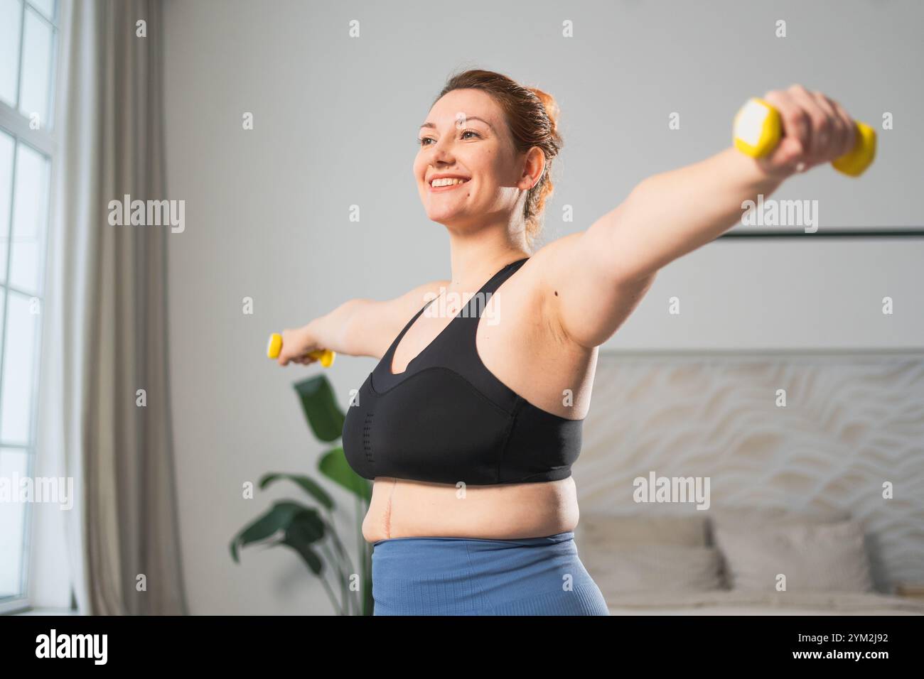Fitness workout training. Woman picking up dumbbells. Plus size female ...