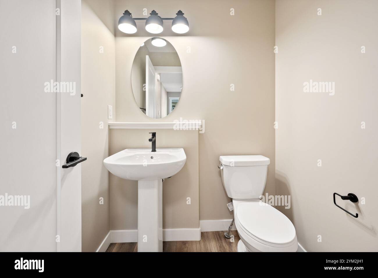 A bathroom with a white toilet and sink. The bathroom is clean and well ...