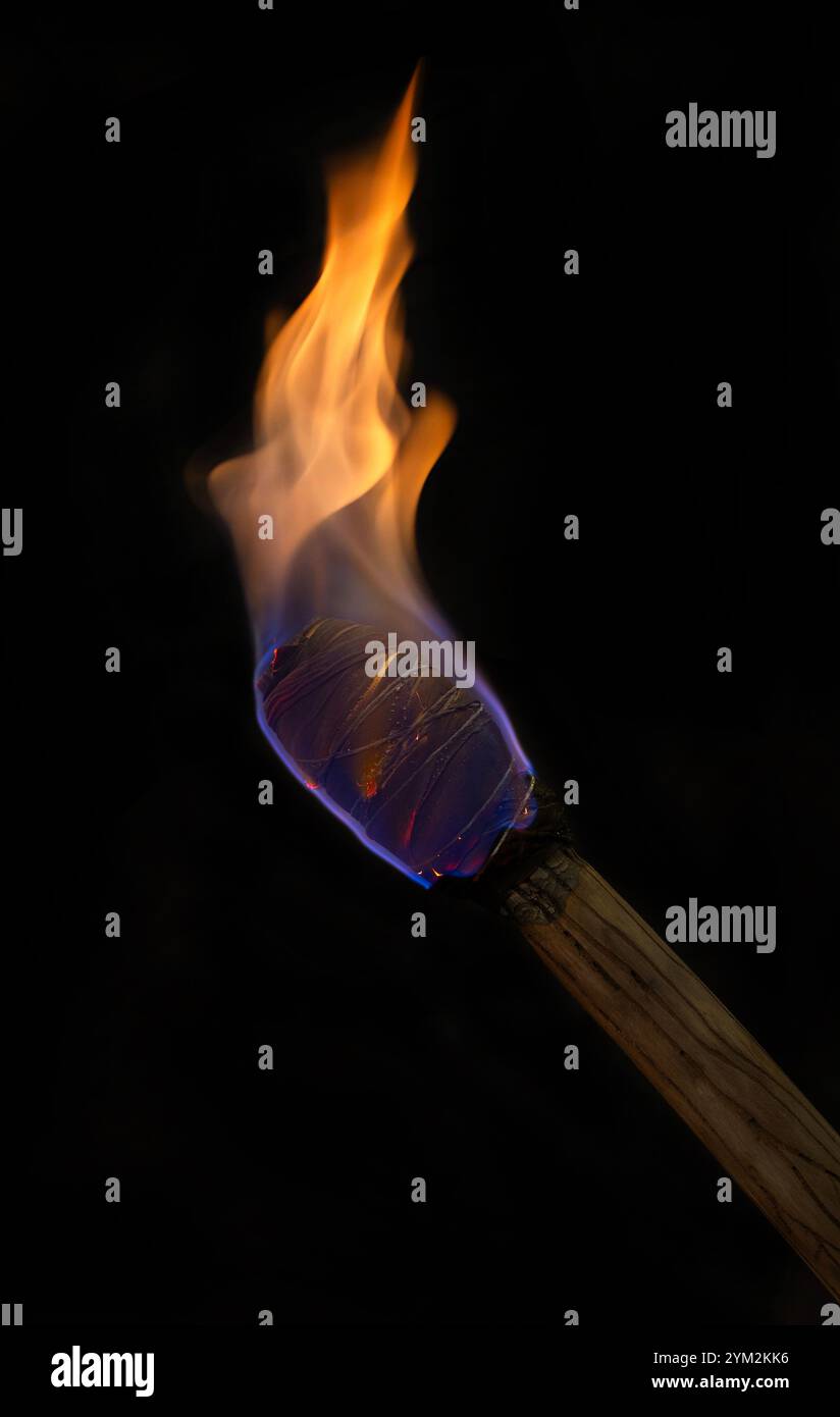 Ancient burning wooden torch on black background Stock Photo - Alamy