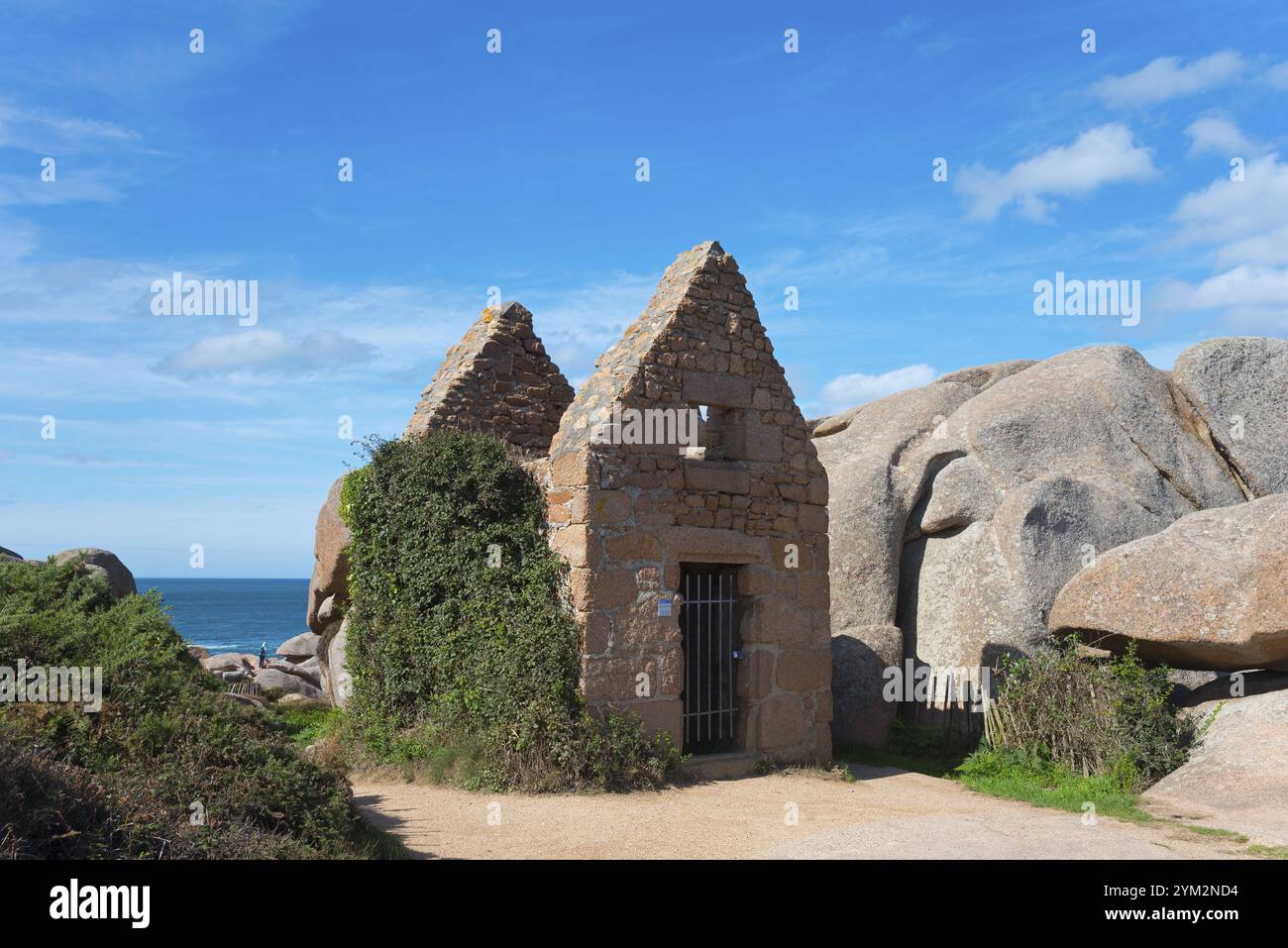 Stone ruin on the coast with sea view, surrounded by rocks and light ...