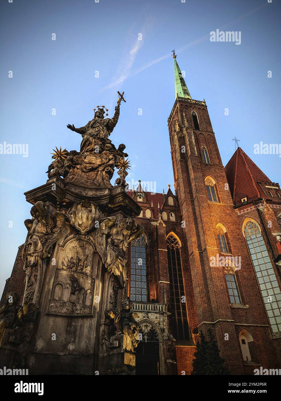 Historical statue and church with Gothic architecture illuminated by ...