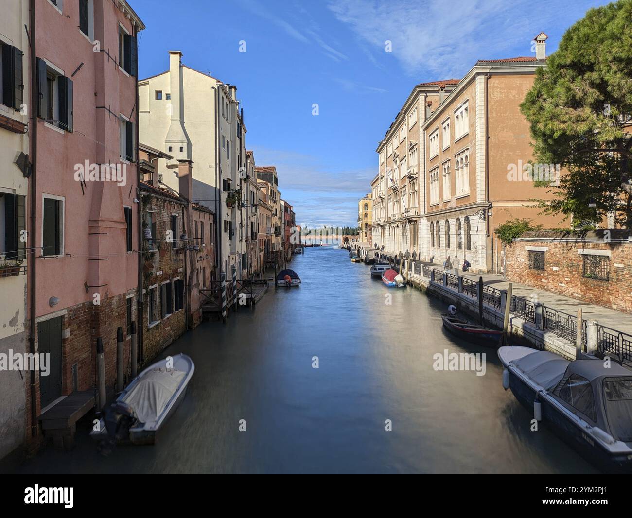 A picturesque canal lined with colorful buildings under a bright blue ...