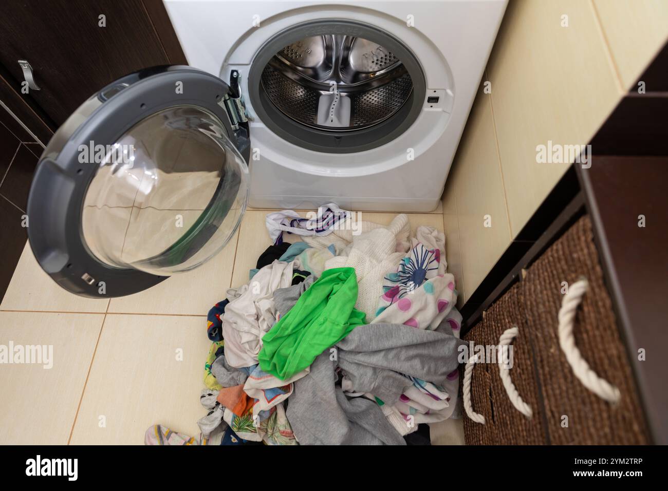 A very messy laundry scene with various clothes strewn all over the ...