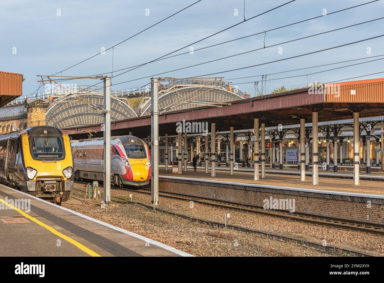 Two trains stand at railway platforms waiting to depart. A historic ...