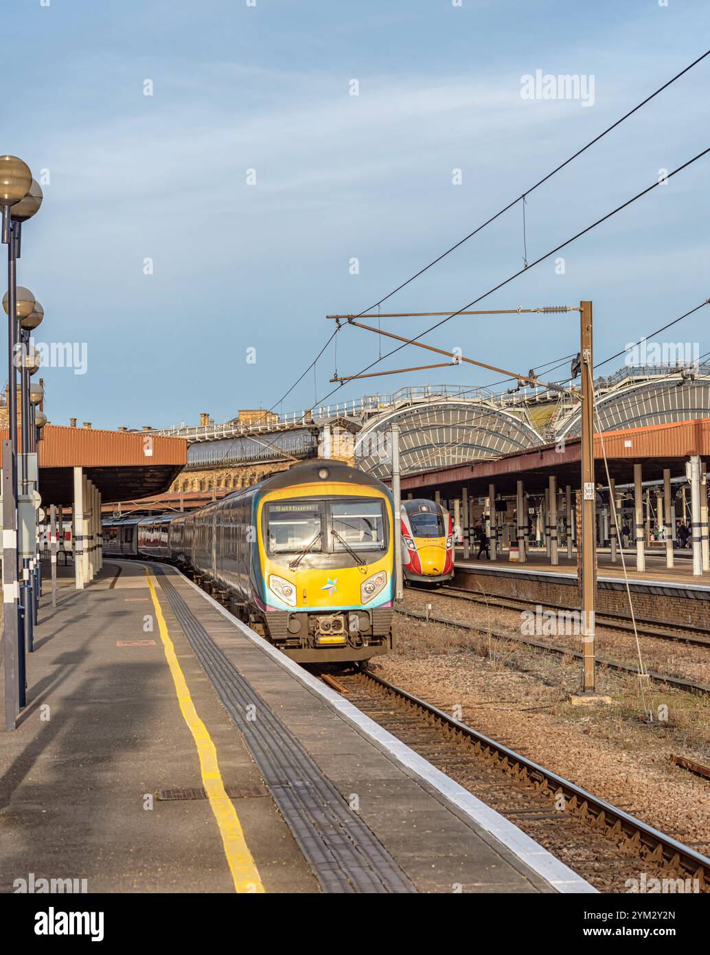 Two trains stand at railway platforms waiting to depart. Two historic ...