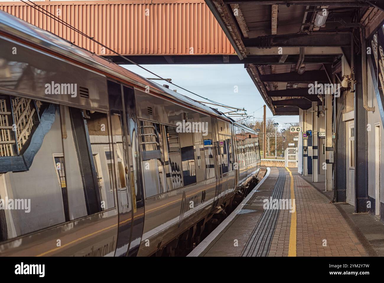 A close-up view of a train standing at a railway station platform ...