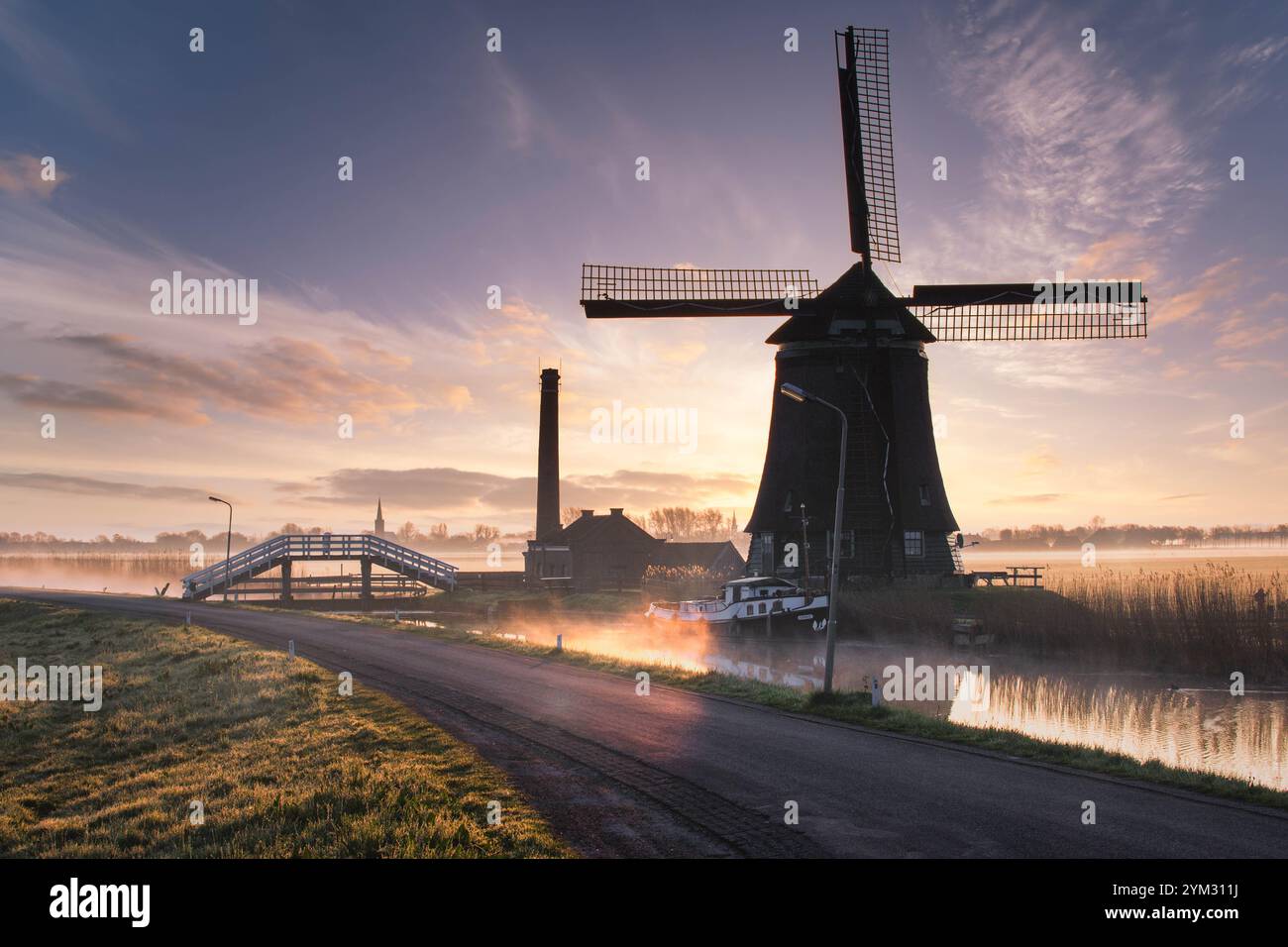 Traditional dutch windmill near the canal during sunrise. Netherlands ...