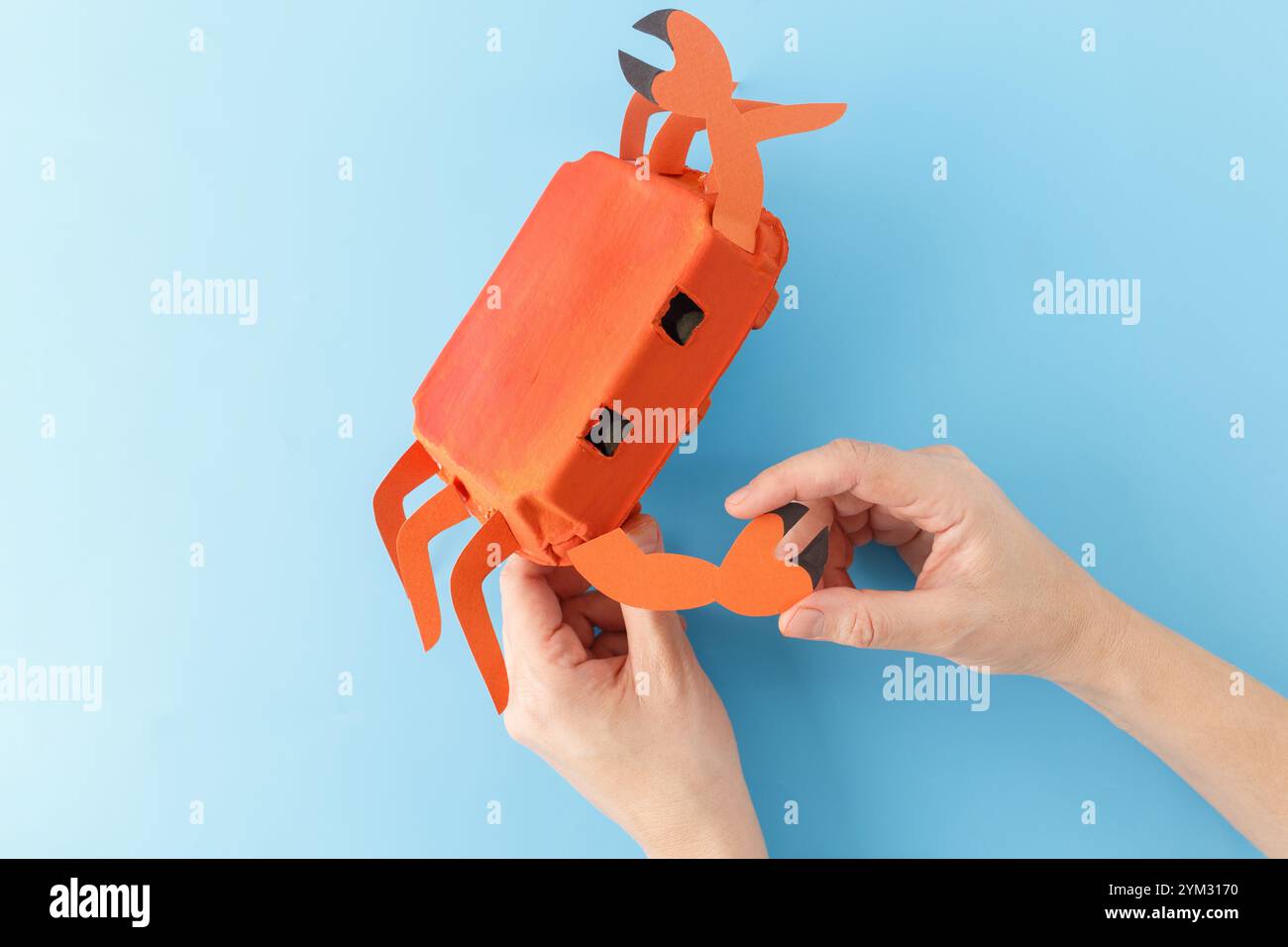 attaching paper details claws to cardboard egg box, process of making ...