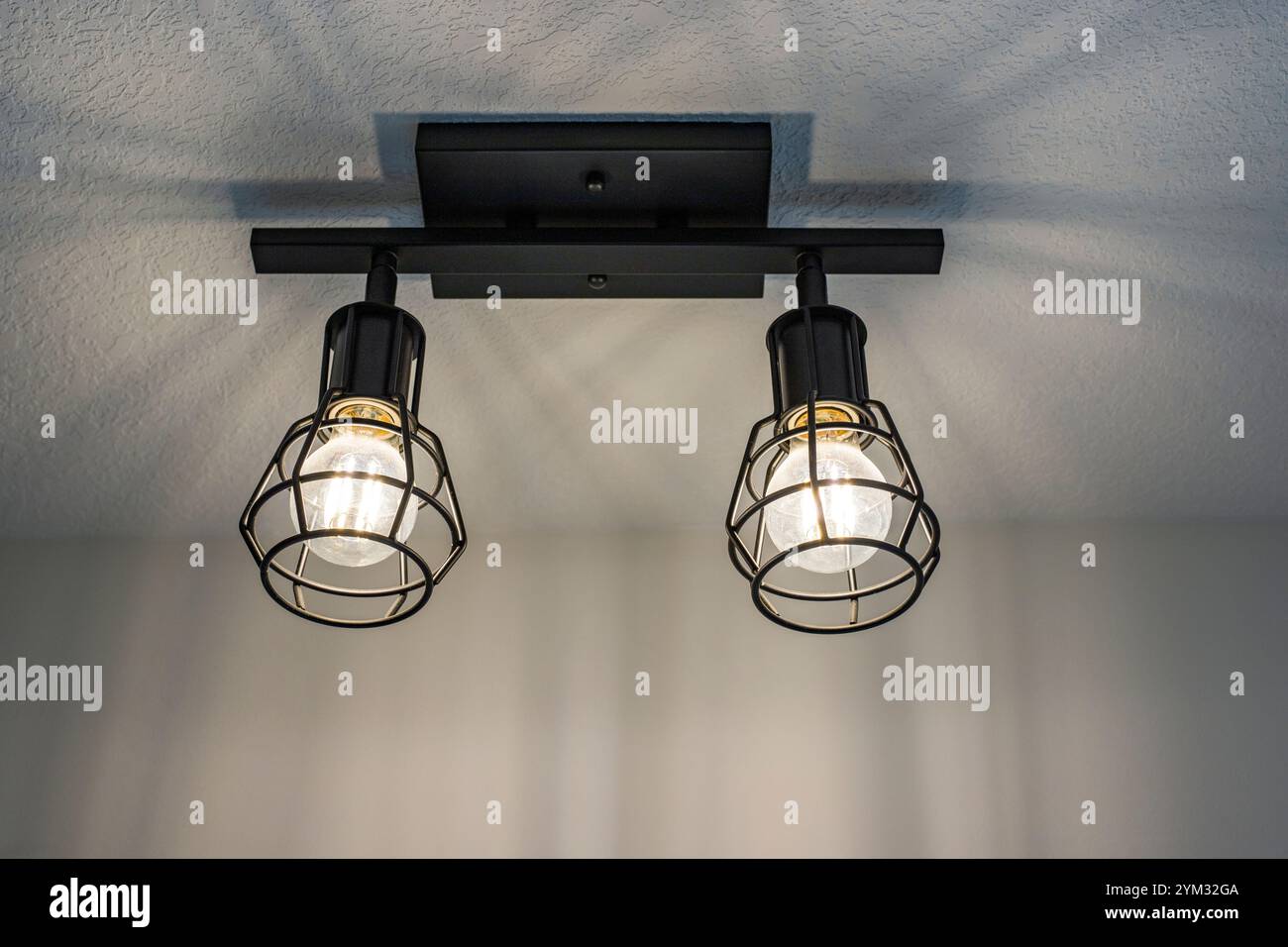 Two light fixtures with a black frame and a white light bulb. The light ...