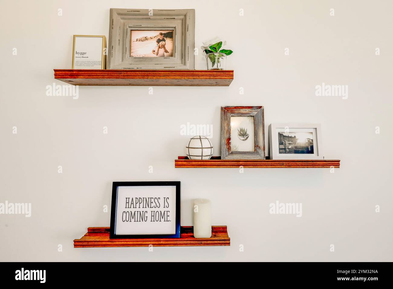 Three shelves with pictures and a sign that says "Rejoice is the ...