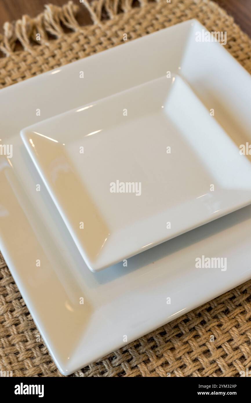 A white plate with a brown border is placed on a brown cloth. The plate ...