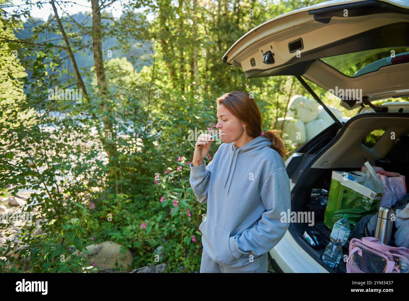 Woman Camping in the Forest, Brushing Teeth by a Car on a Peaceful ...