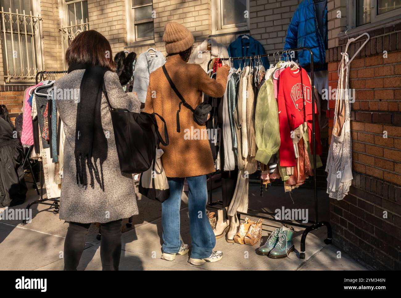 Shoppers browse used clothing on trendy Bleecker Street in the ...