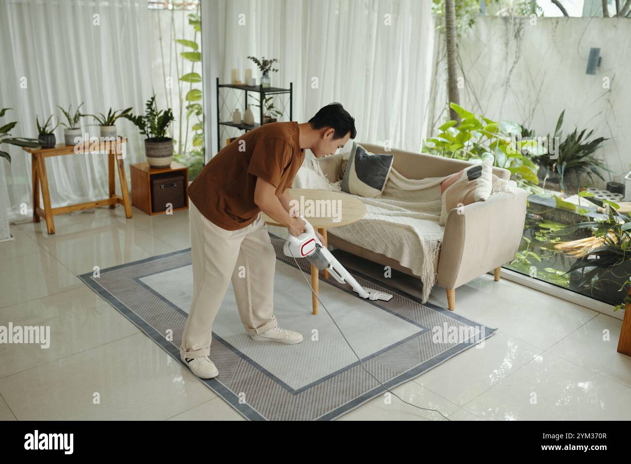 Cleaning Living Room with Cordless Vacuum Cleaner Stock Photo - Alamy