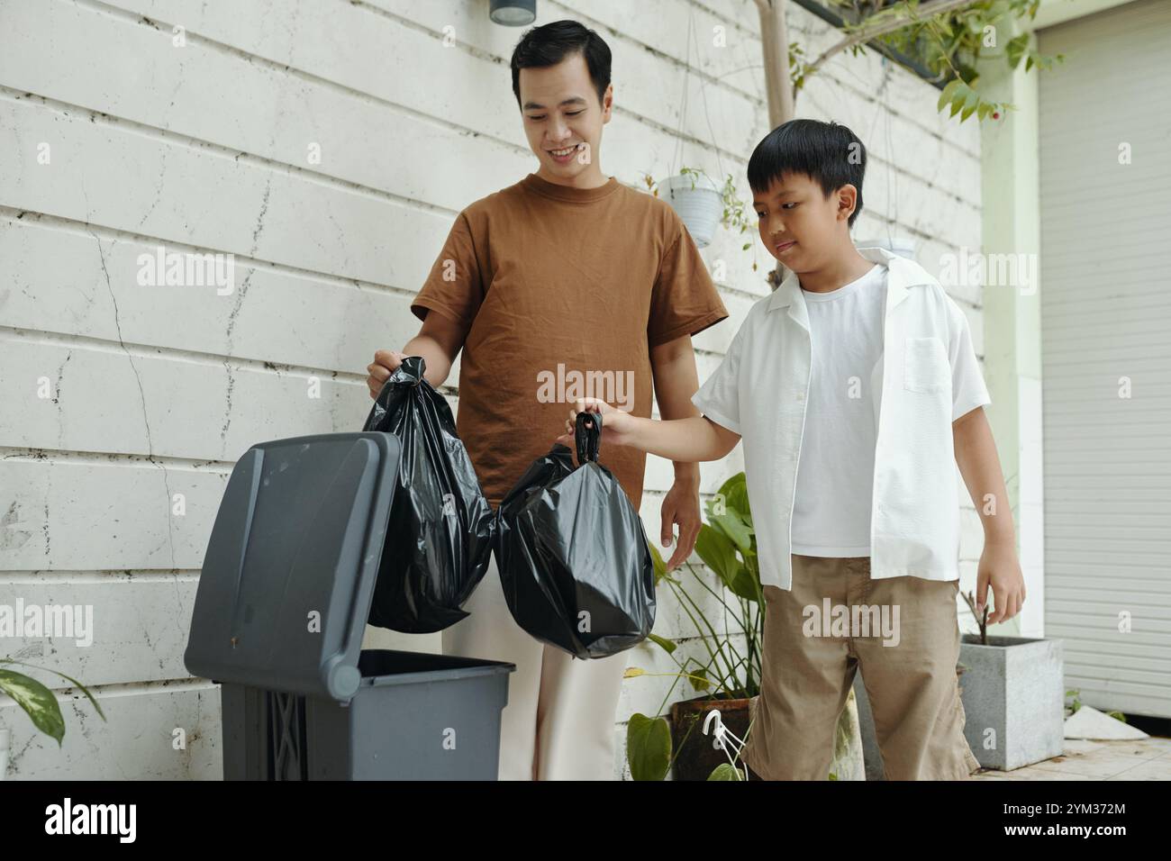 Father and Son Disposing Garbage Together Outdoors Stock Photo - Alamy