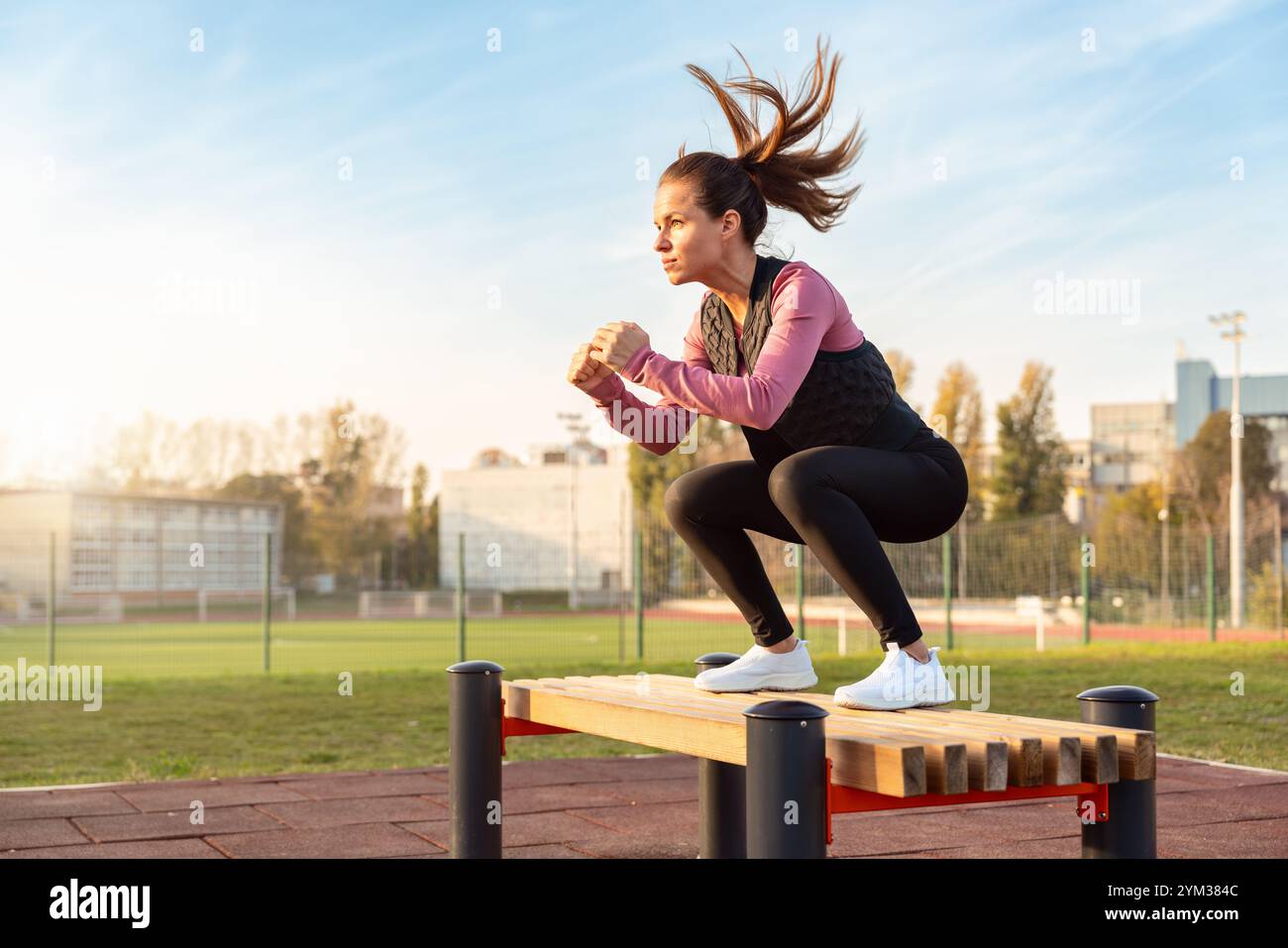Young Caucasian woman doing workout exercise on sports ground outdoors ...