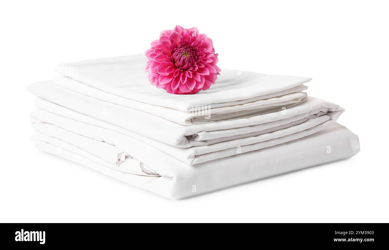 Stacked bed linens and pink flower on white background Stock Photo - Alamy