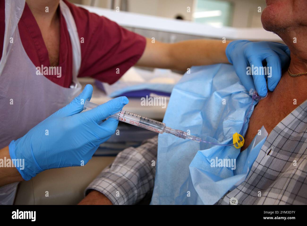 Close up of Nurse Holding line to port open whilst using flush - saline ...
