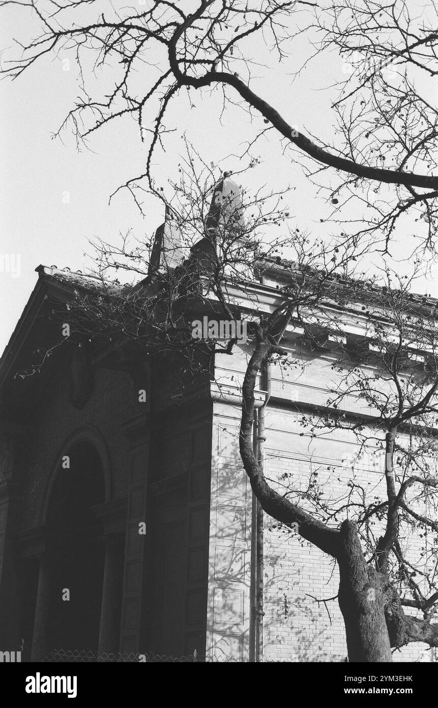 A black and white photograph captures a classical building with arched ...