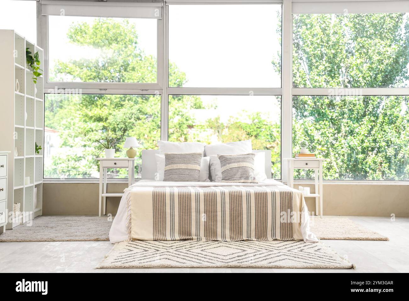 Interior of bedroom with big bed, tables and window Stock Photo - Alamy