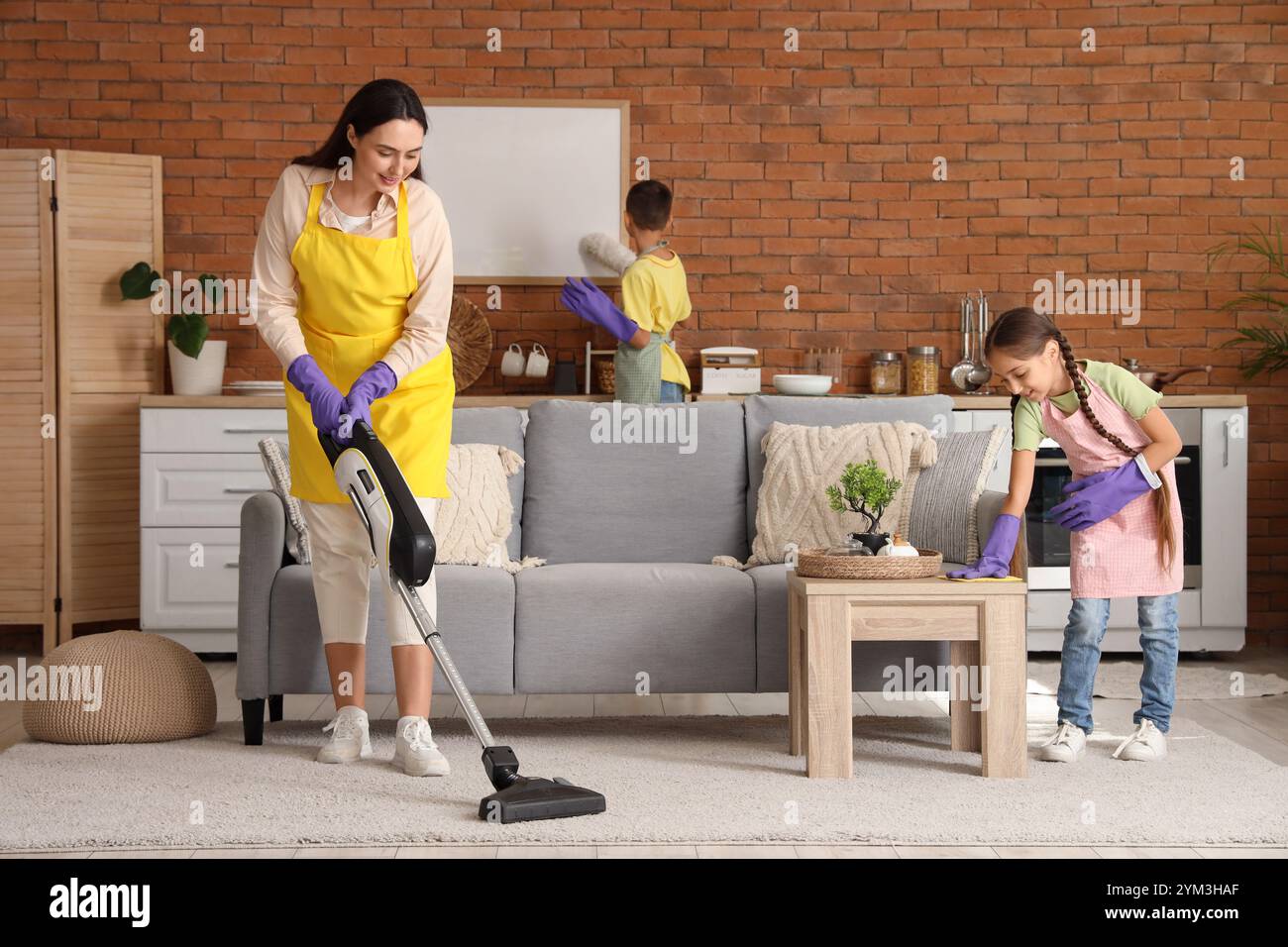 Cute little children helping their mother with cleaning routine at home ...