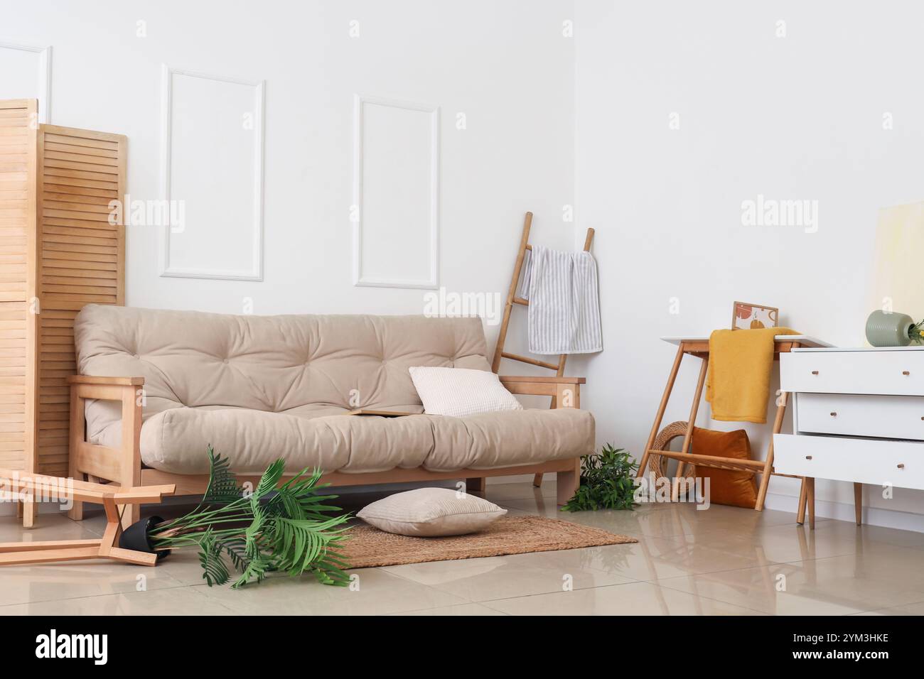 Interior of messy living room with white sofa and overturned furniture ...