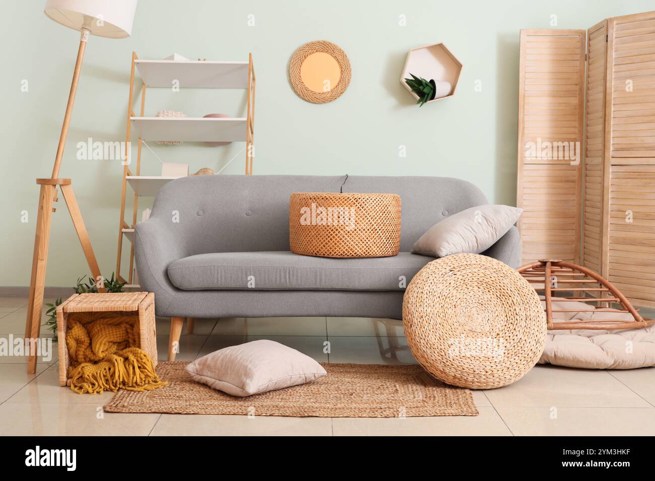 Interior of messy living room with grey sofa and overturned furniture ...