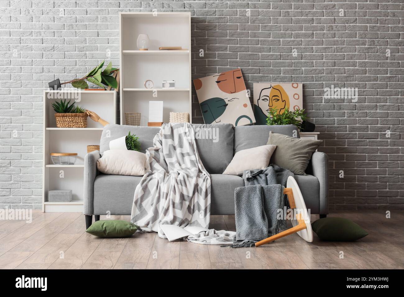 Interior of messy room with sofa and overturned furniture after ...