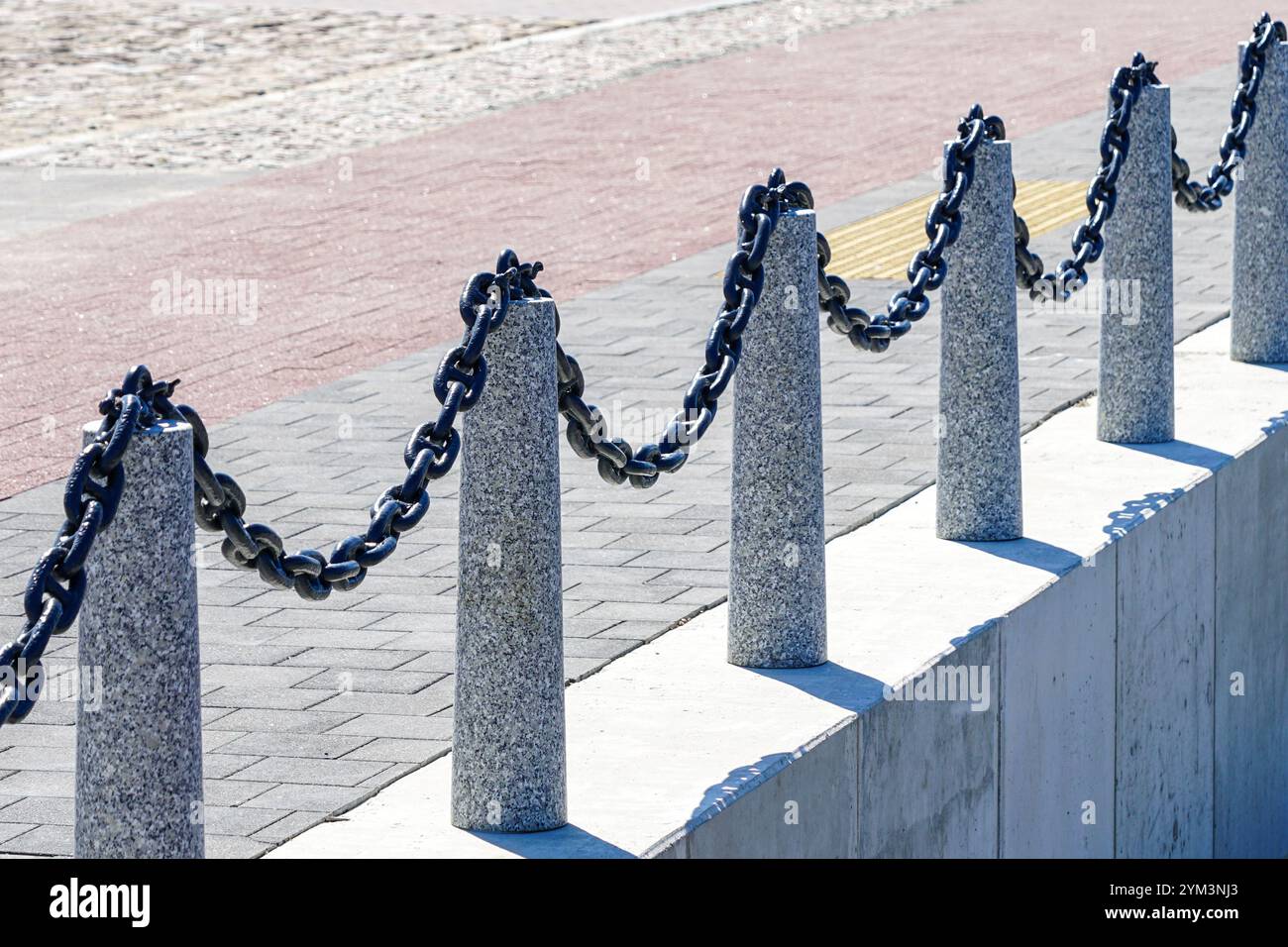 Concrete posts connected by a metal chain enclose the waterfront in the ...
